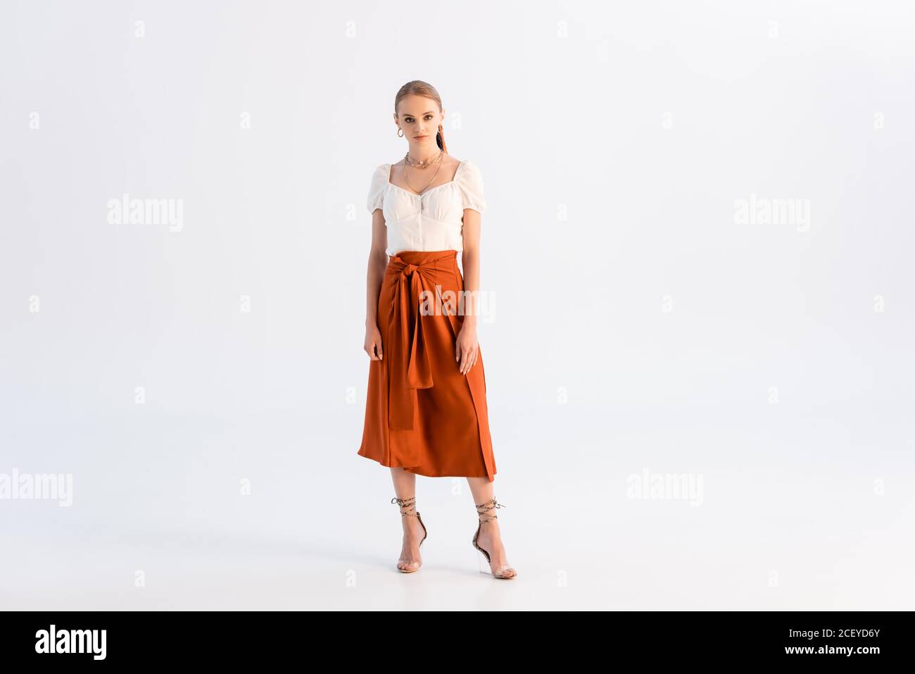 full length view of fashionable woman posing on white Stock Photo - Alamy