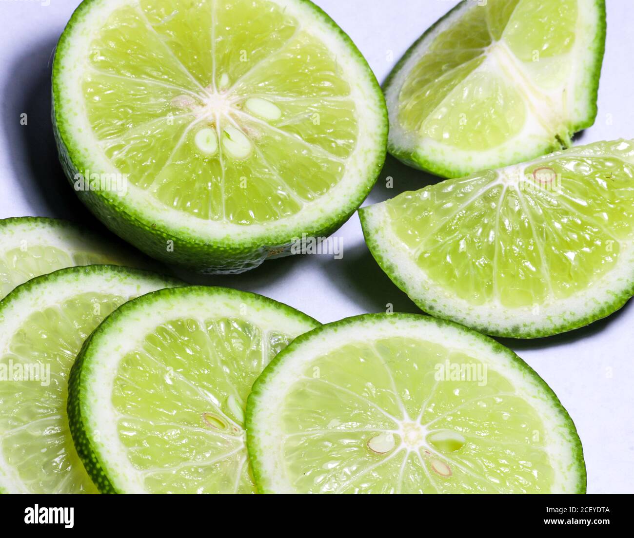 Green lime wedge on white background Stock Photo - Alamy