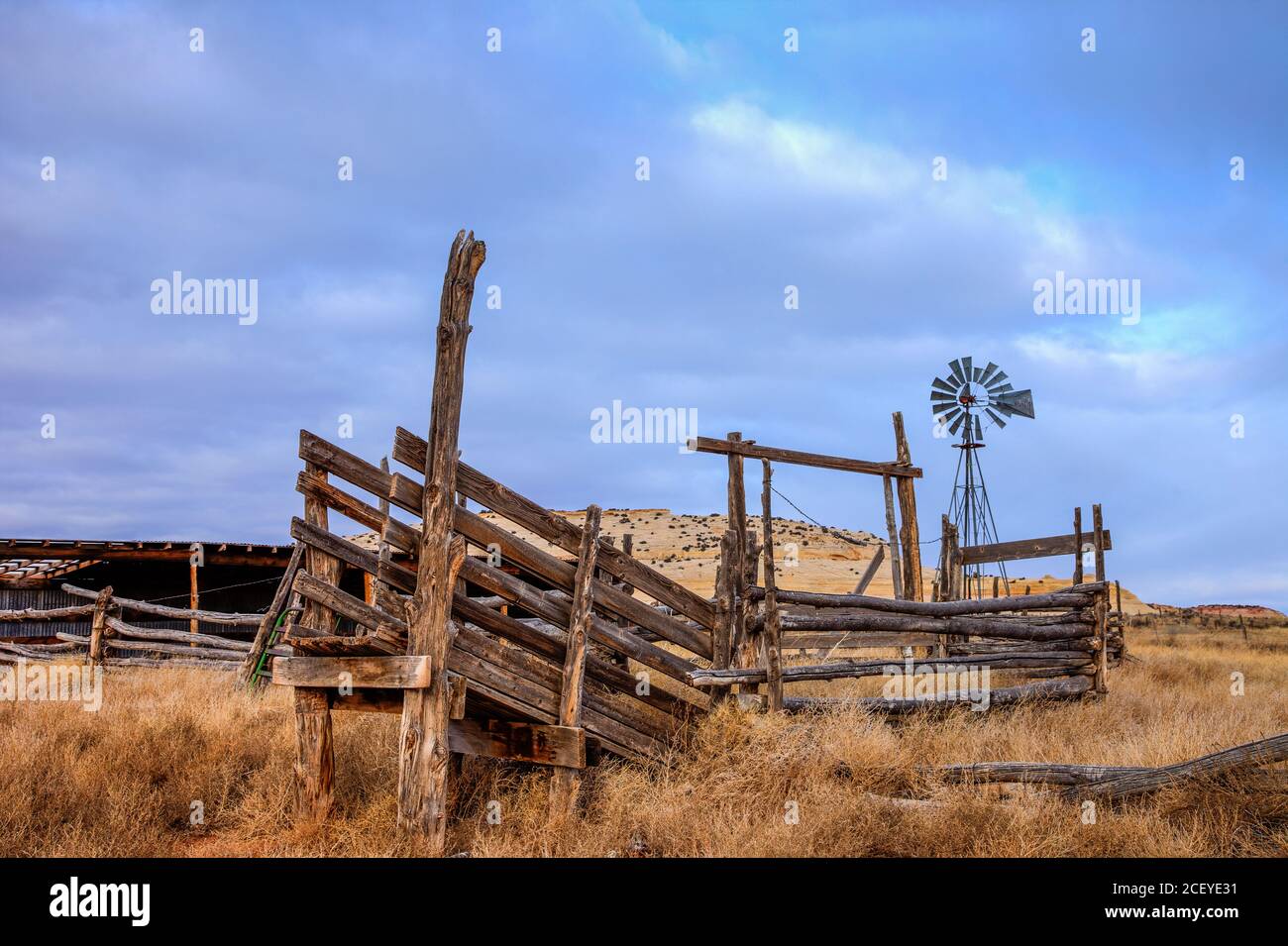 A windmill behind an old wooden pole fence cattle corral and loading ...