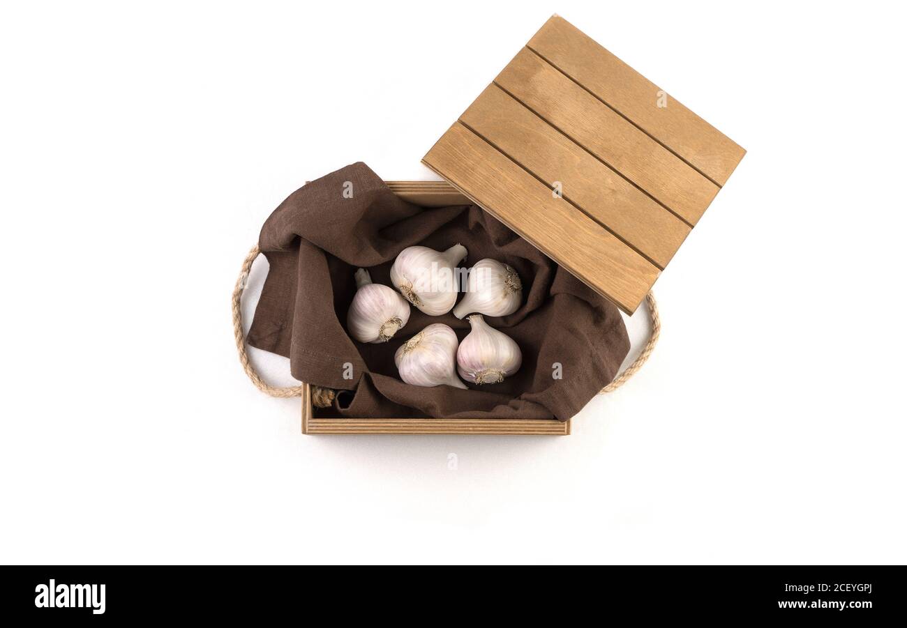 White garlic isolated on a white background, side view, in a wooden box ...