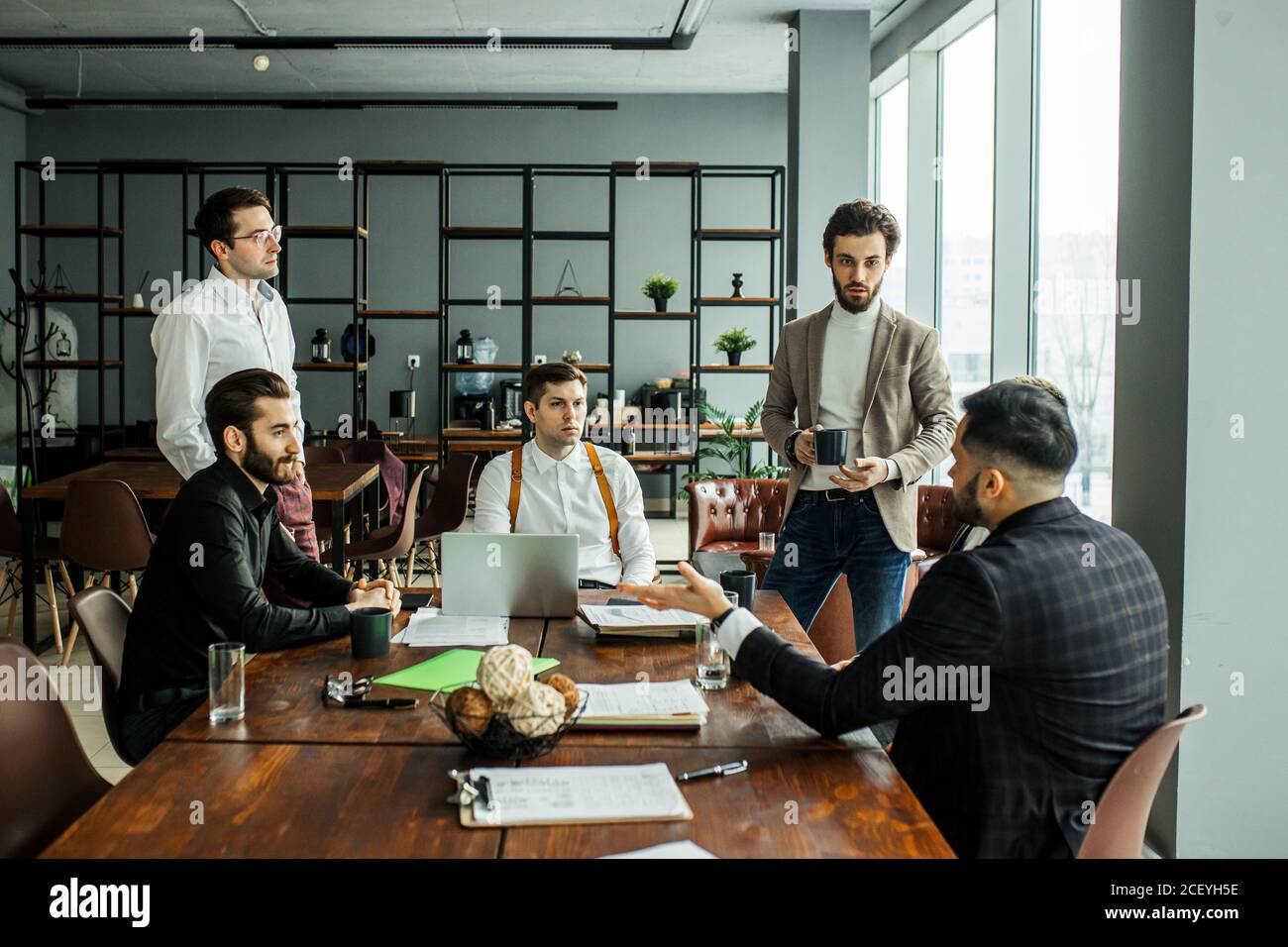 young caucasian business leaders gathered in office for coworking, hold ...