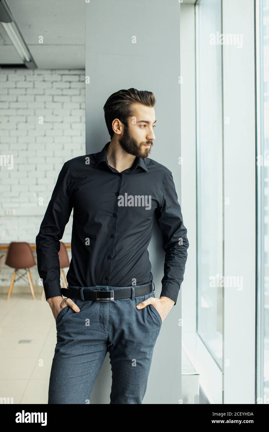 business man in office, wearing black formal suit stand next to ...