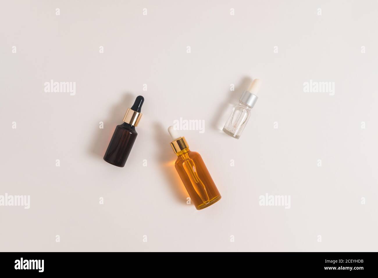 White, orange and black serum bottles on white background. Cosmetic ...