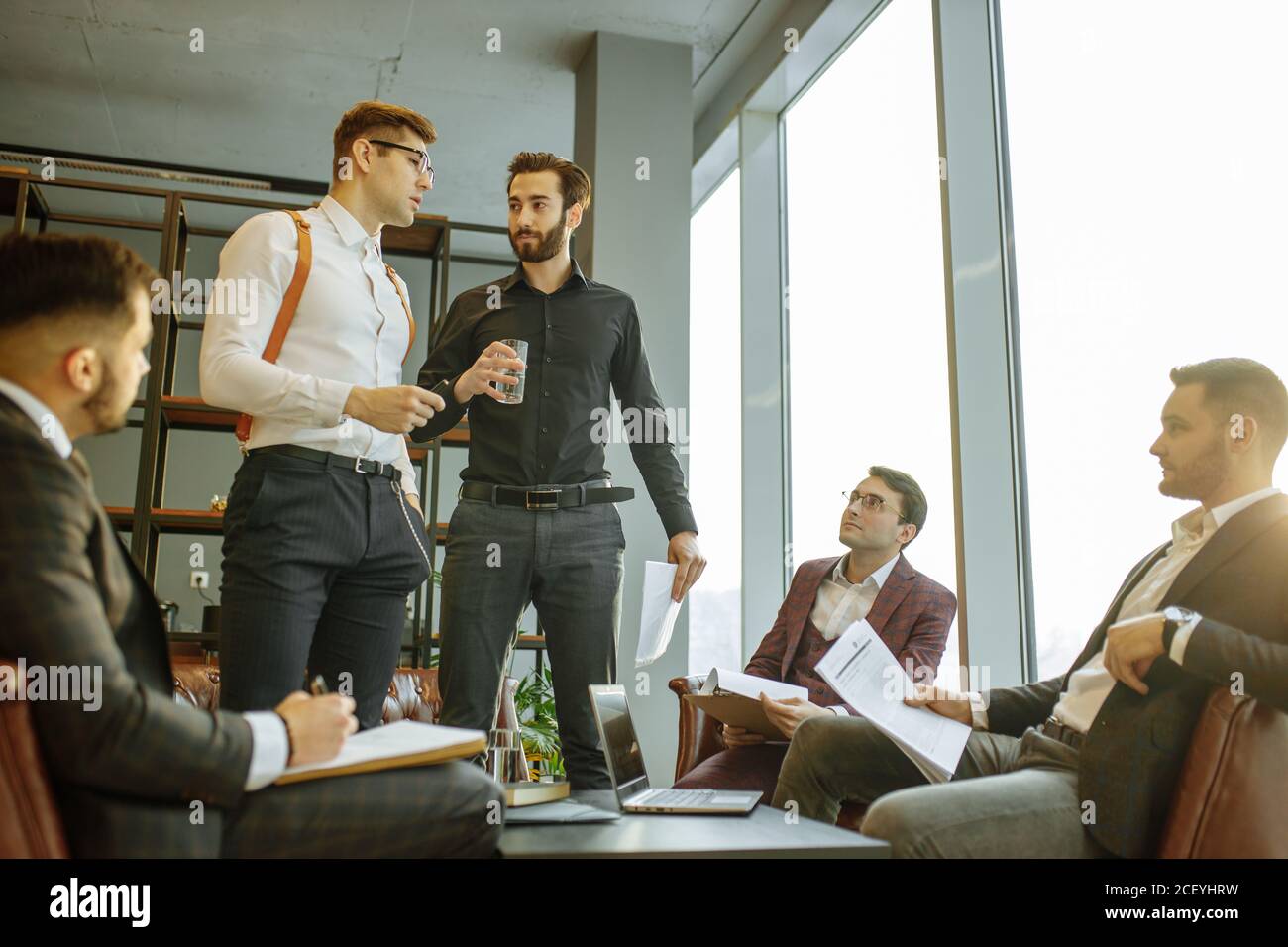 two young caucasian bearded men in formal shirts stand giving speech to ...