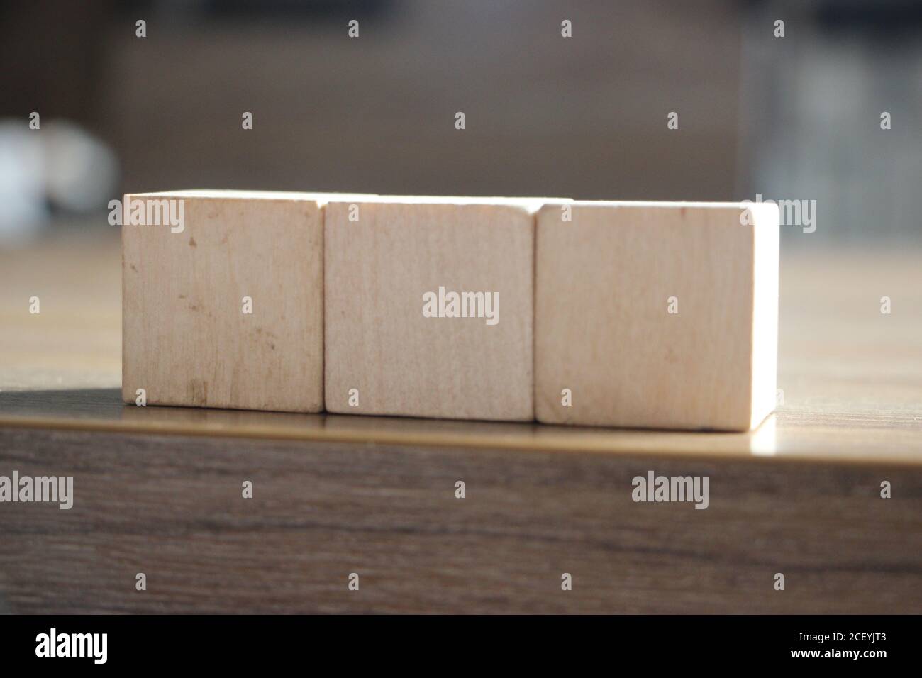 3 Wood Blocks Front View, On Wooden Table, Light-Grey Background Stock ...