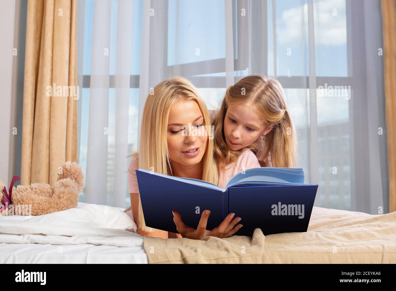 Mother and daughter in the bad by morning Stock Photo - Alamy