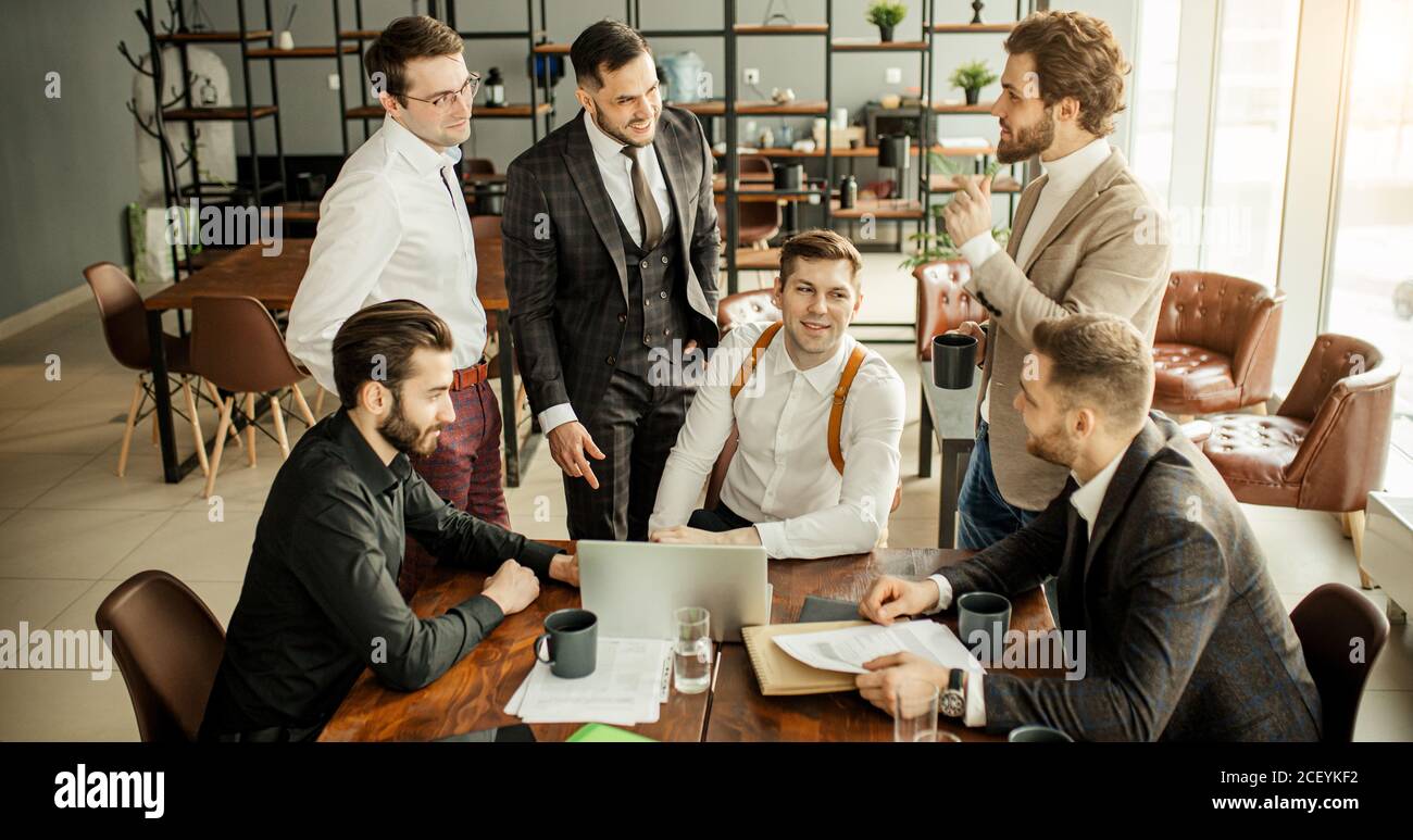 serious confident business people coworking in office, using laptop ...