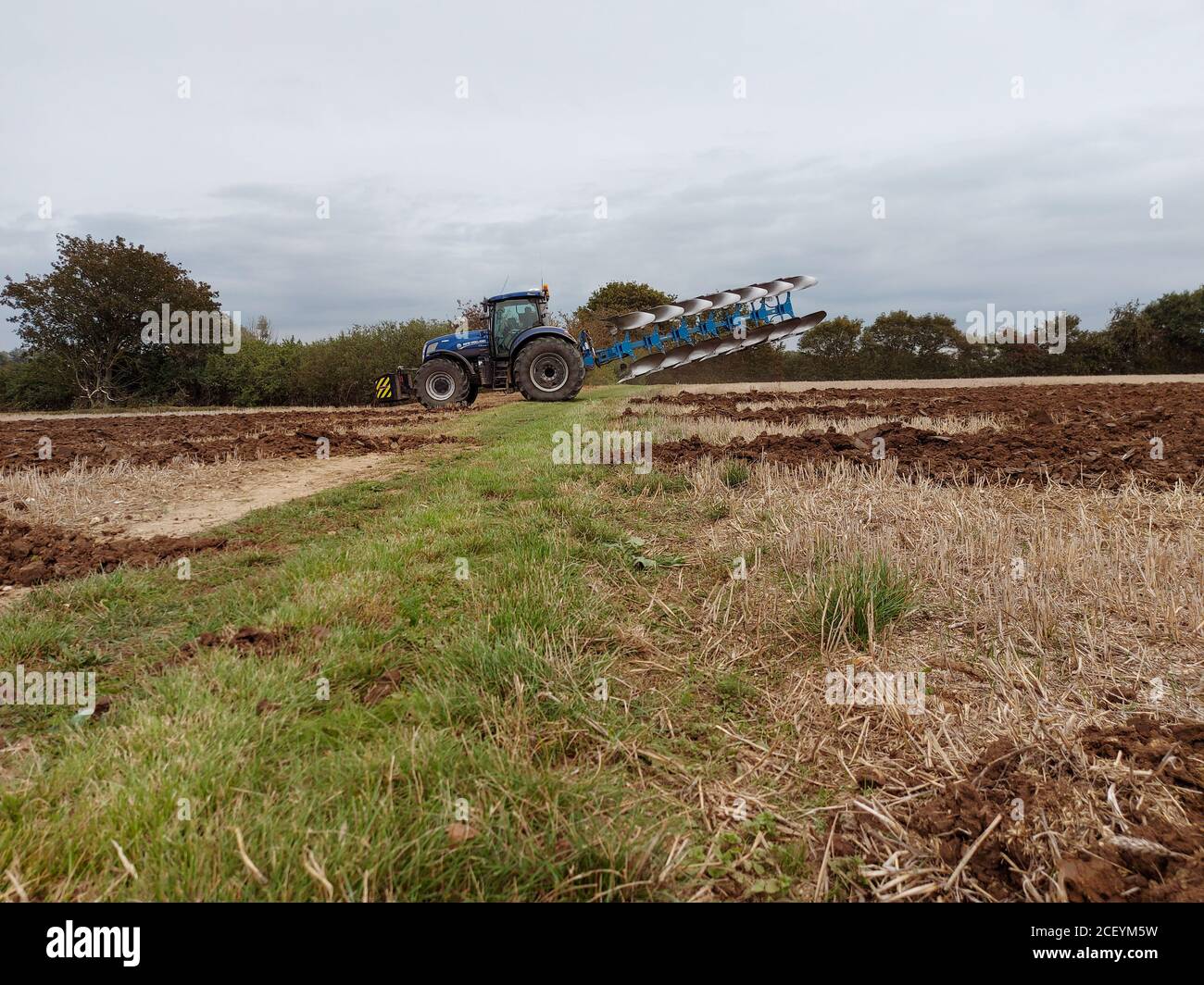 Tractor crossing between fields while ploughing, harvest land ...