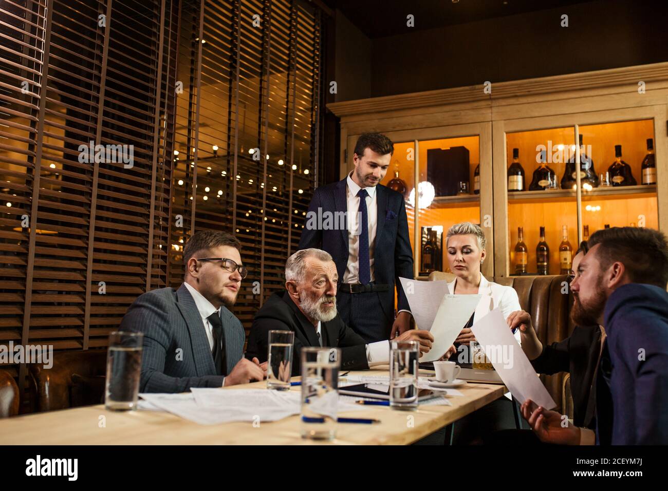 Strict female leader in white jacket with short hair sitting at the ...