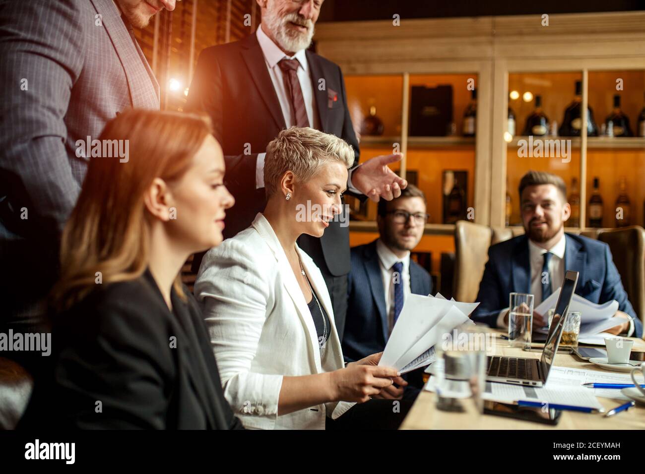 Close up of young smiling businesswoman reading paper documents at ...