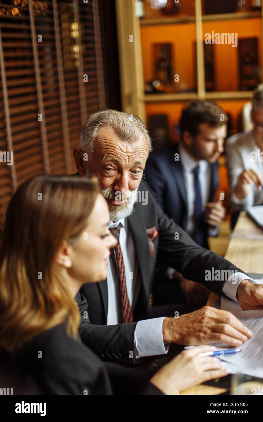 Old respectful man with wrinkles, in nice suit and tie friendly talking ...