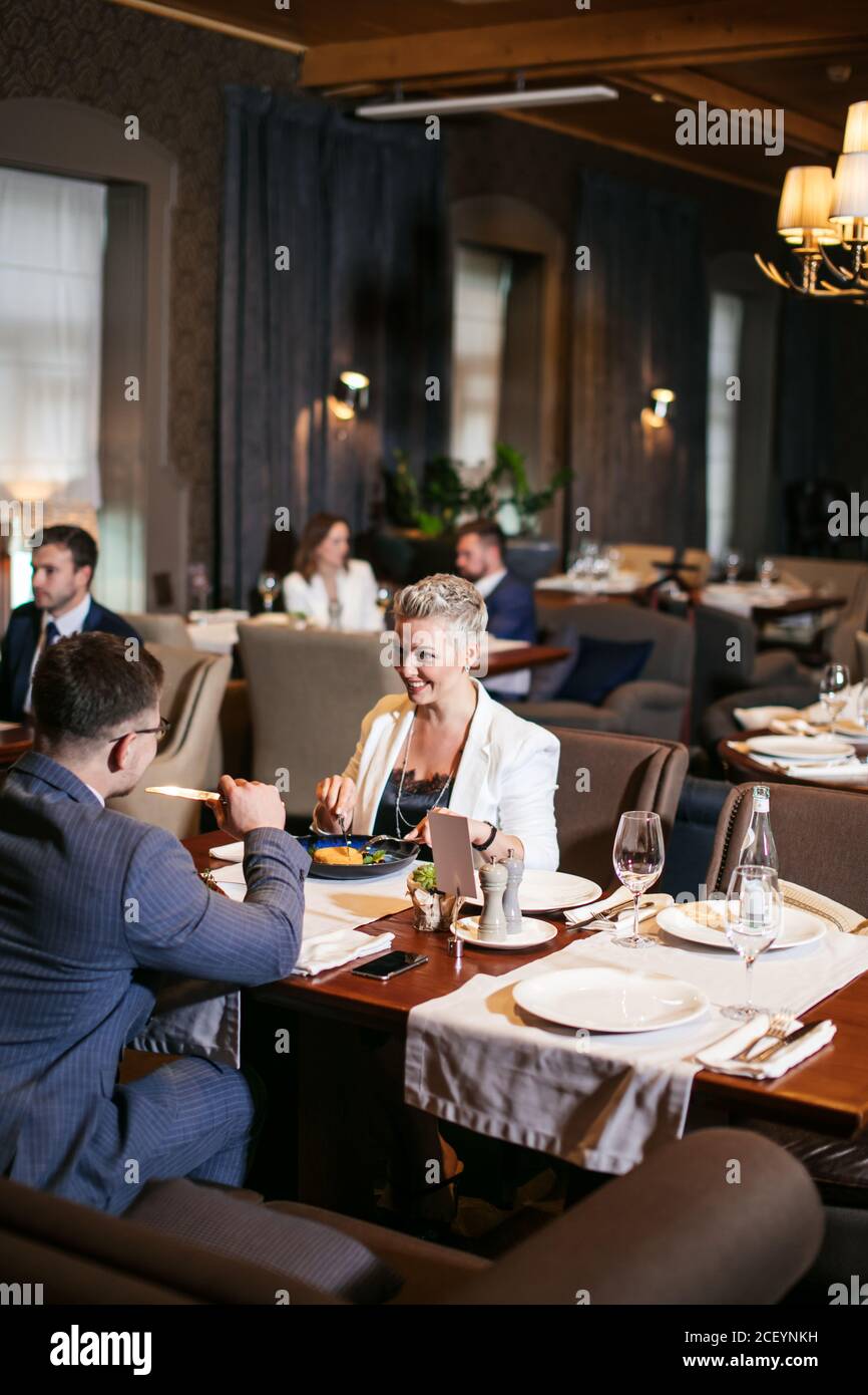 Charming blonde well dressed woman with short haircut actively talks to ...