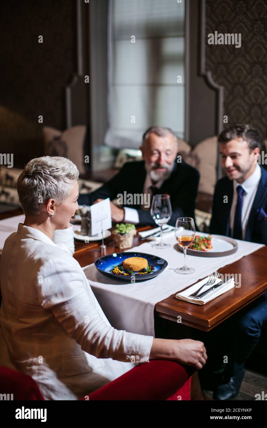 Group of generous friends enjoy dinner in beautiful restaurant, close ...