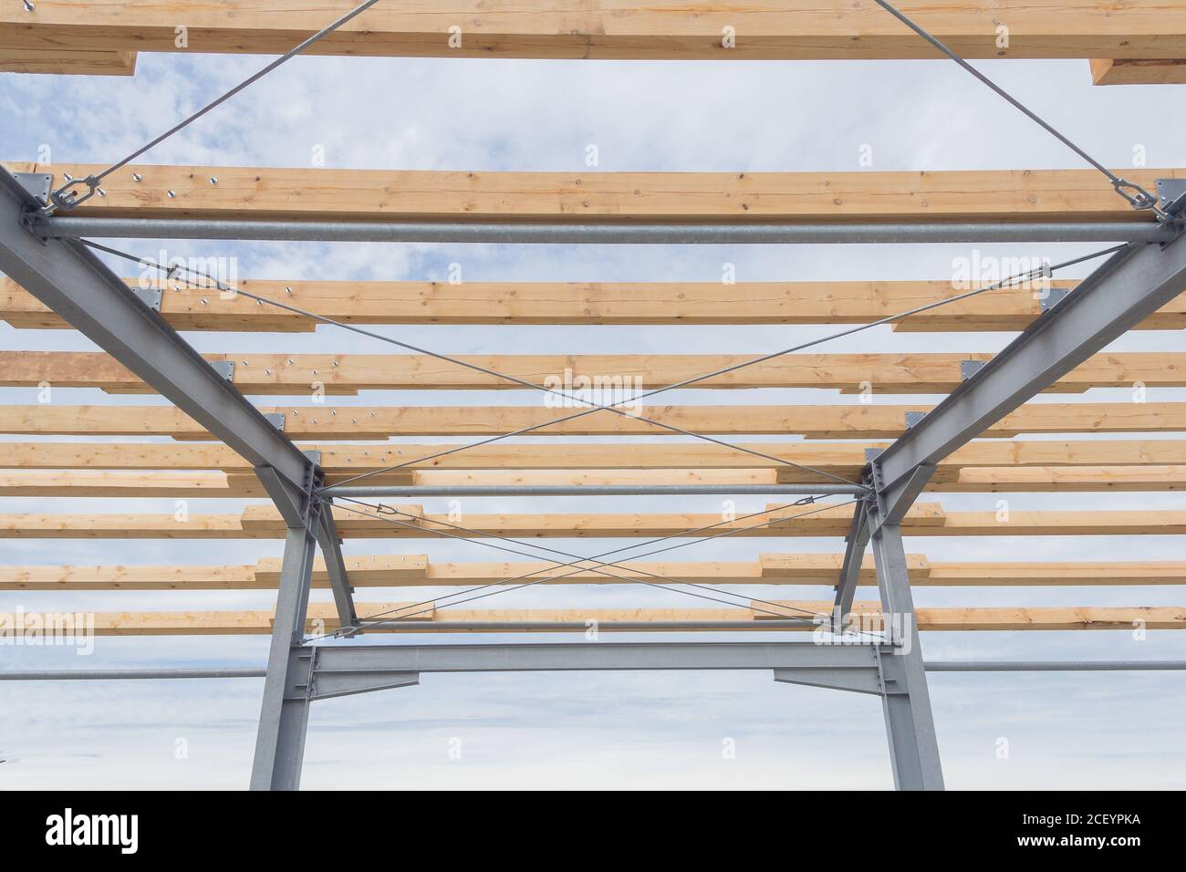 Wooden roof beams on the steel frame of a building under construction ...