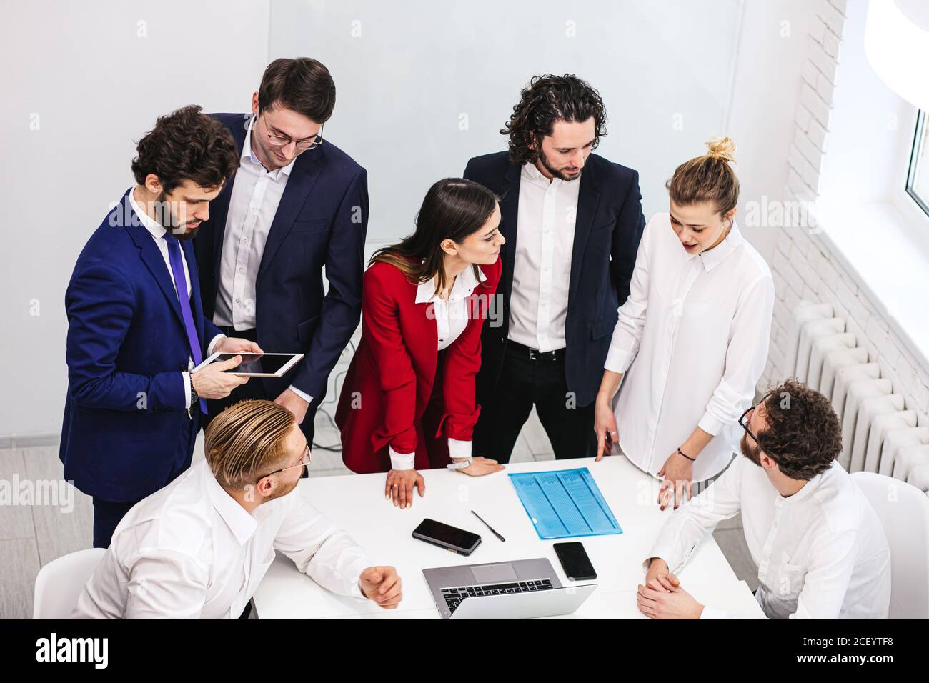 young business leaders gathered in modern office for discussion ...