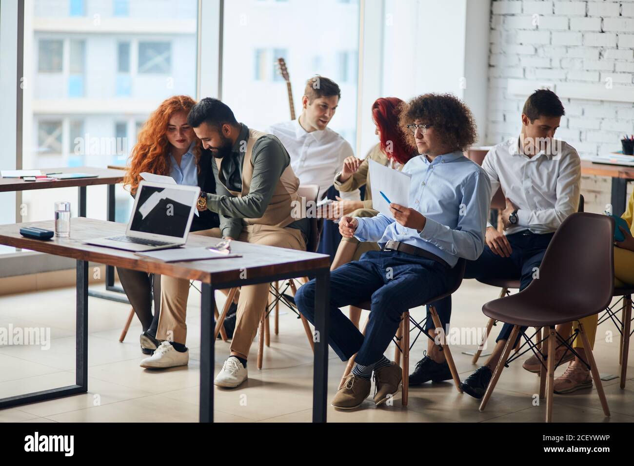 multiethnic group of young workers discuss ideas engaged in educational ...