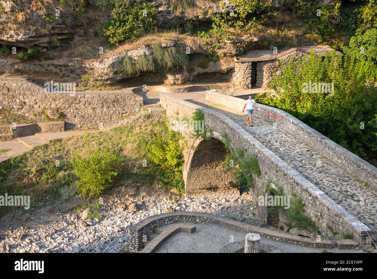 A man walks across the ancient Ribnica Bridge in the old town area of ...
