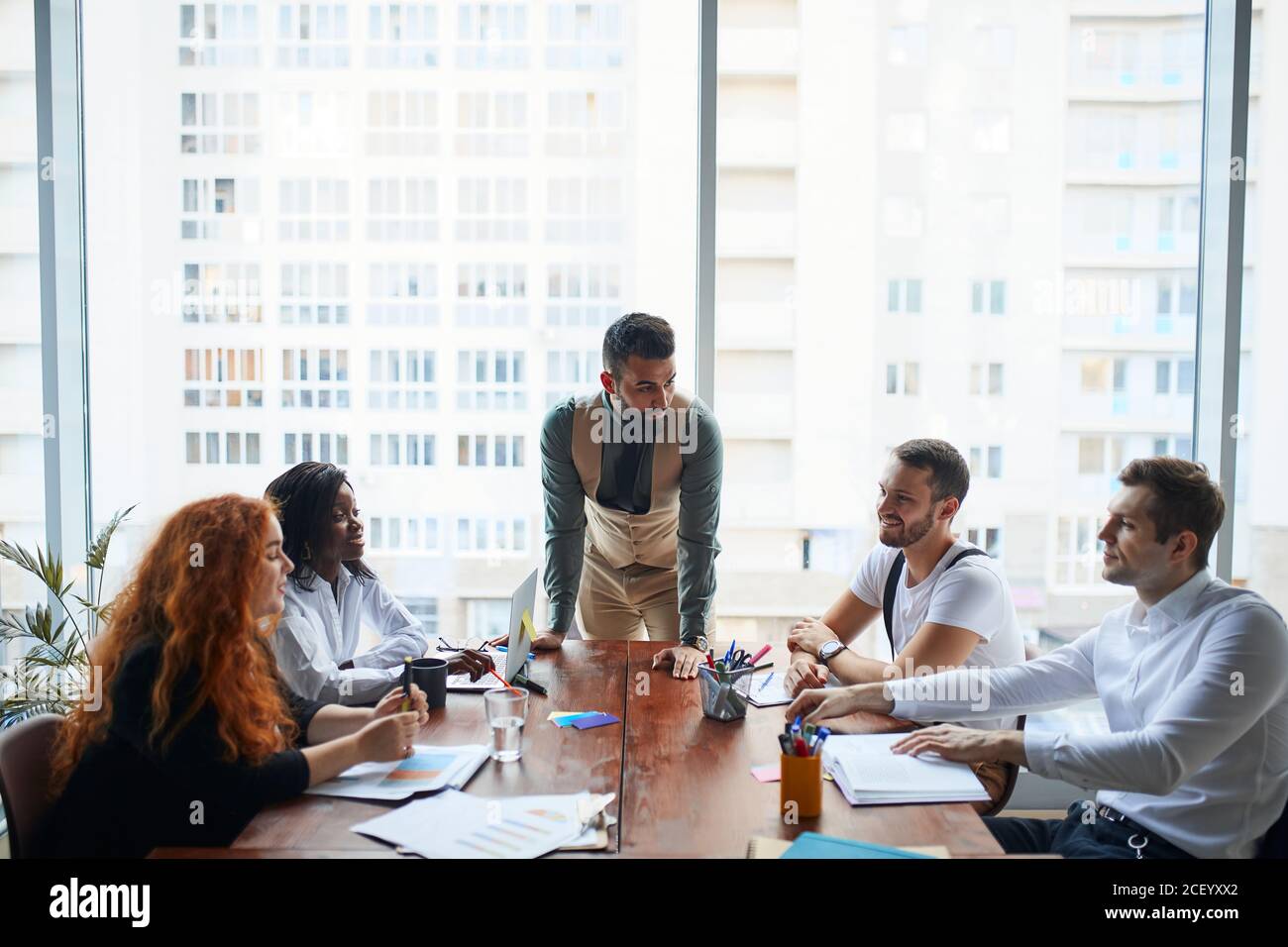 Confident man teaching young friendly happy leaders, coach talking with ...