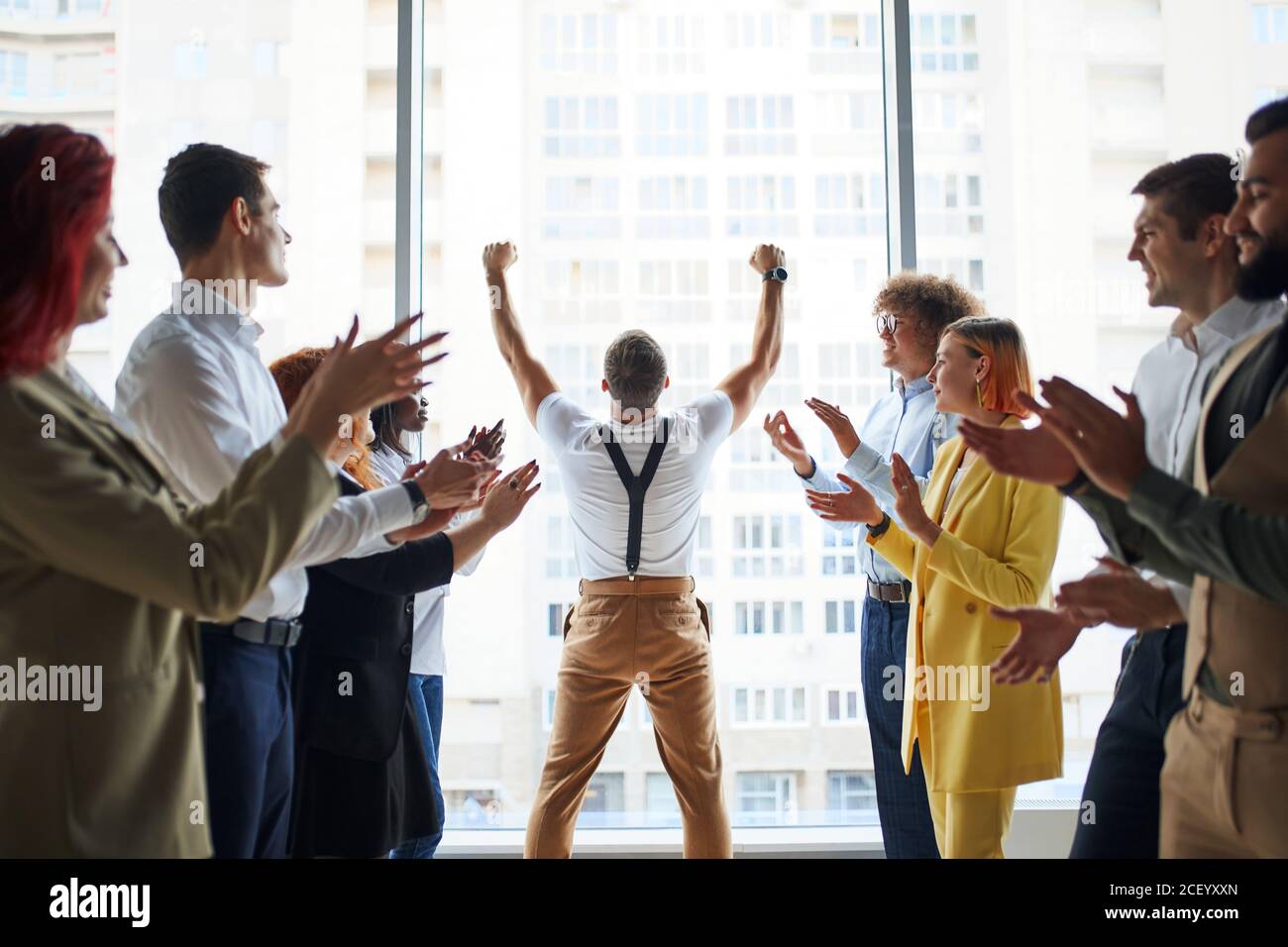 Happy business team is clapping their hands in modern workstation ...