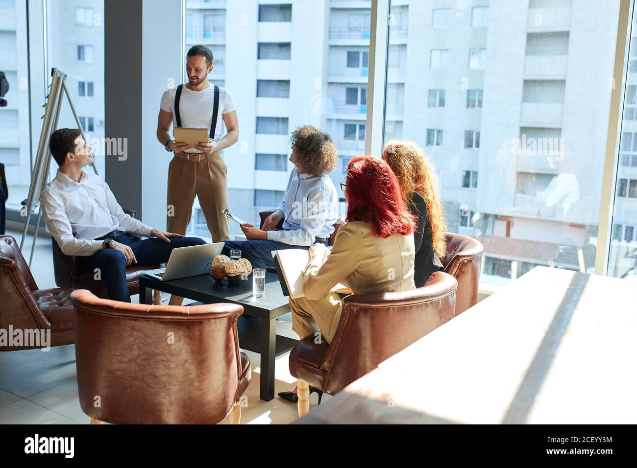 An employee reading report to his boss and a group of workers. Men and ...