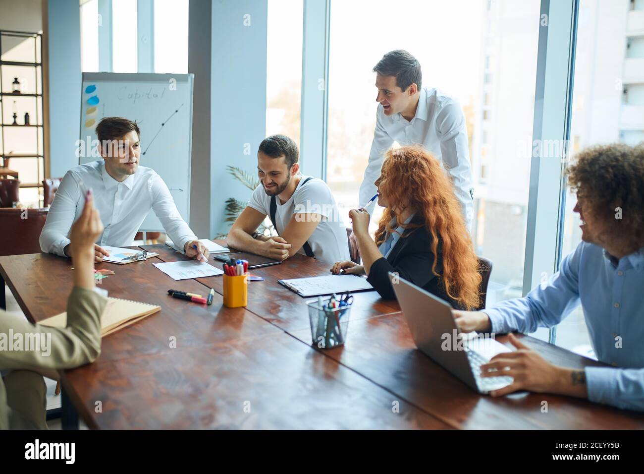 A business consultant explaining his ideas and methods to a group of ...