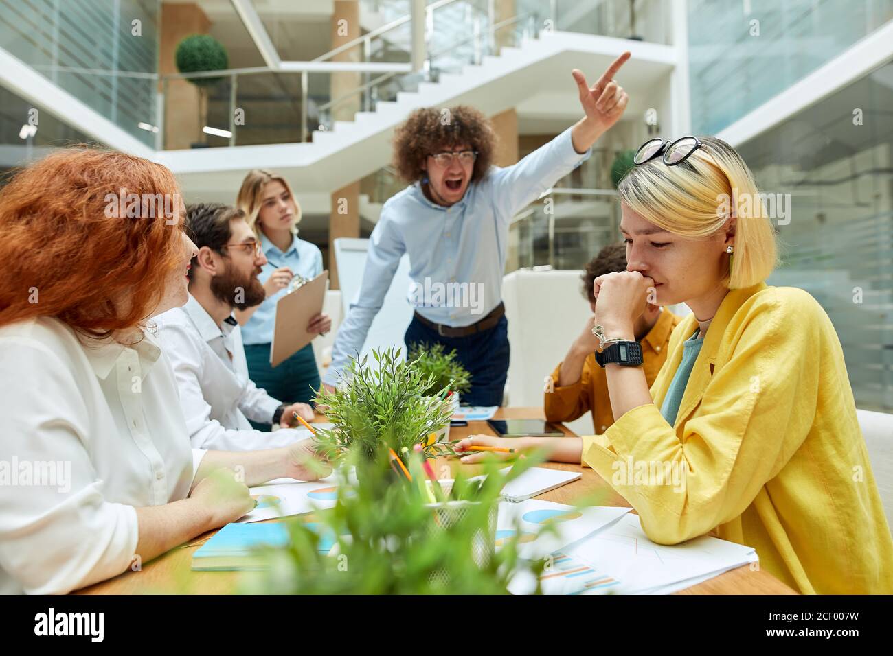 Angry severe boss yells loudly at upset young female designer, raises ...