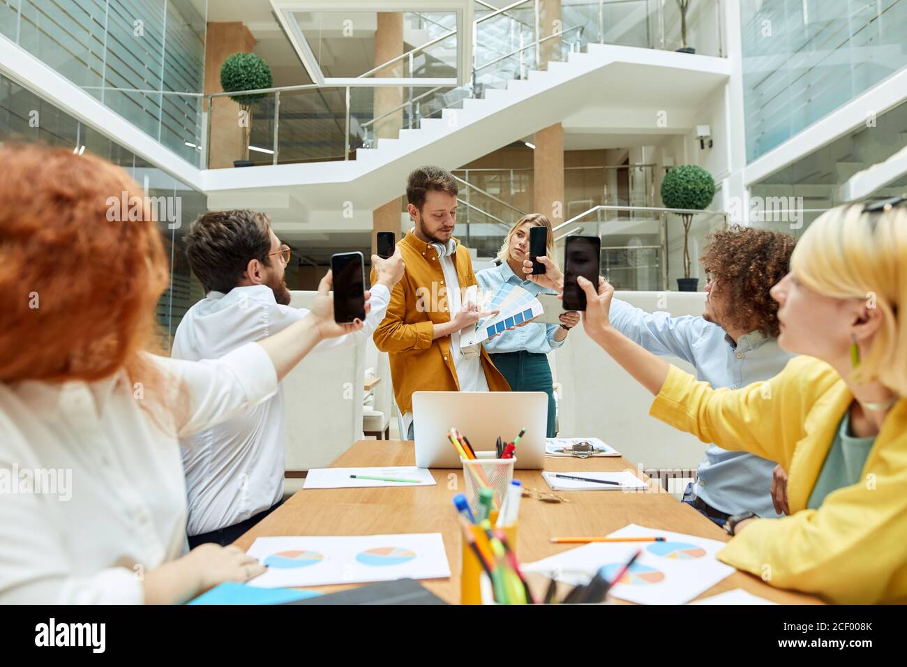 Attractive team leader demonstrates samples of colour for design ...