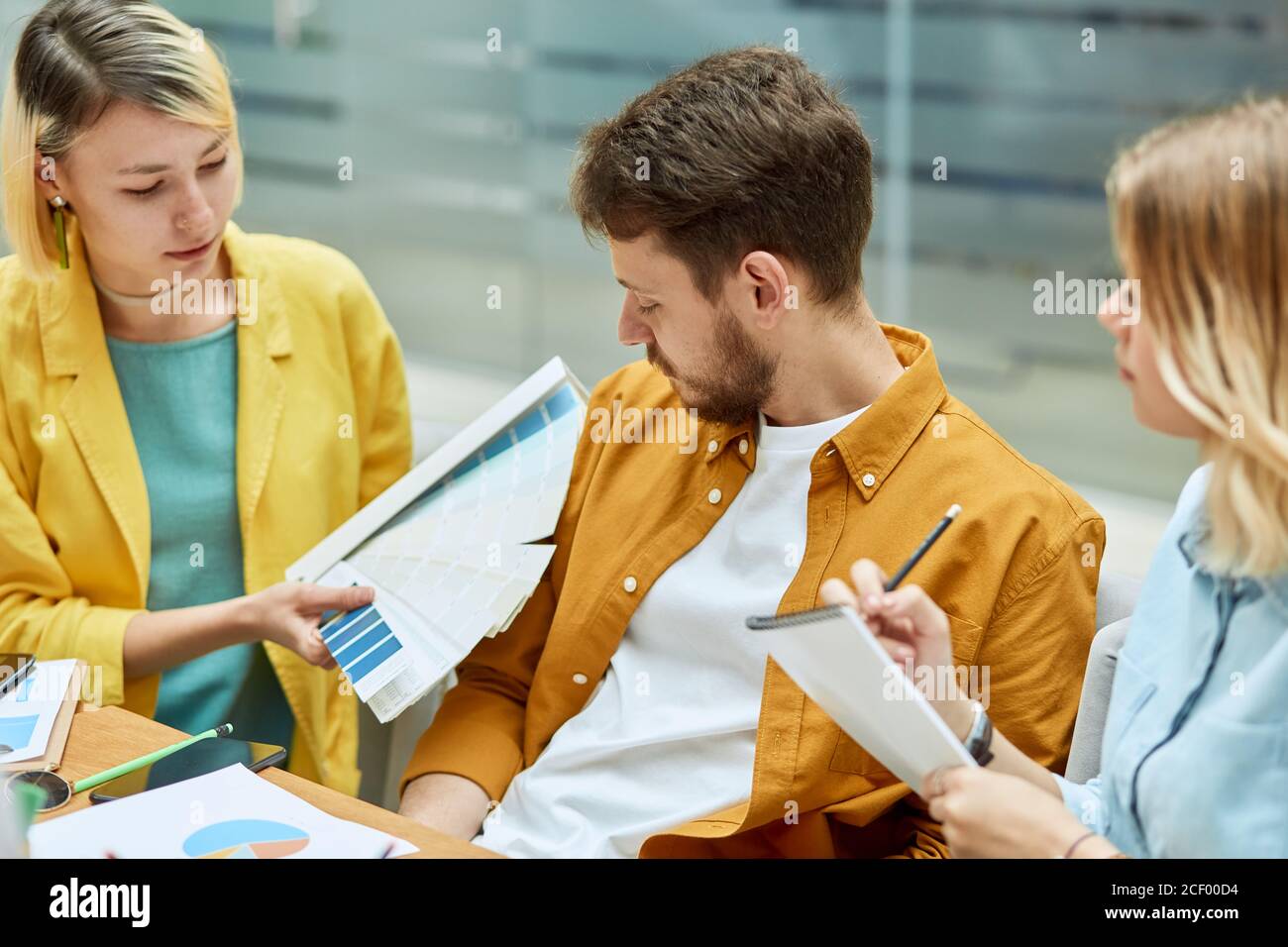 Group of creative young guys choose necessary colour, focus on colour ...