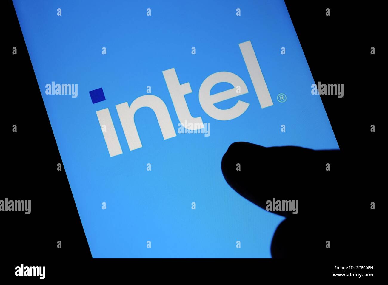 New Intel logo seen on the screen and blurred fingertip touching it in ...