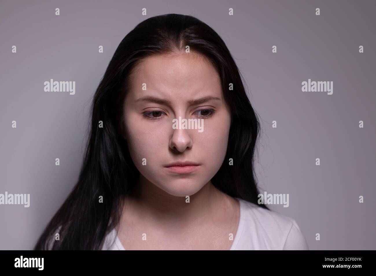 portrait of sad and depressed young woman. on gray background. nervous ...