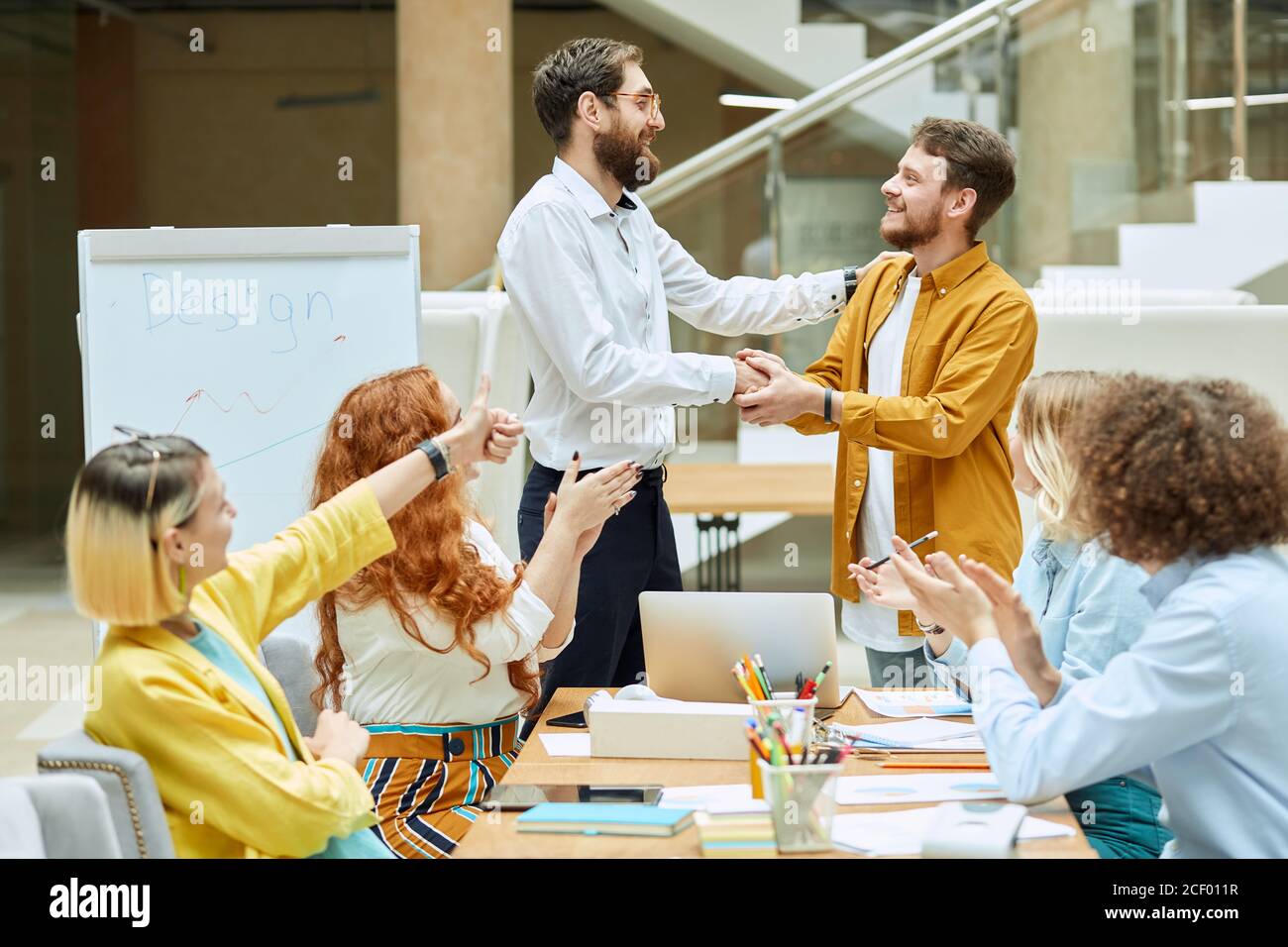 Handsome smart guy with stylish beard, smiles broadly, shakes hand with ...