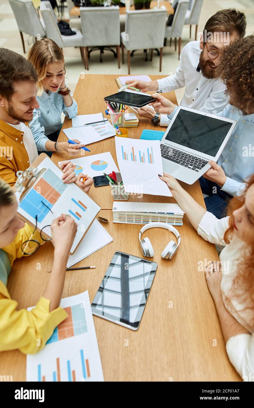 Charming delighted group of young designers brainstorming in a good ...