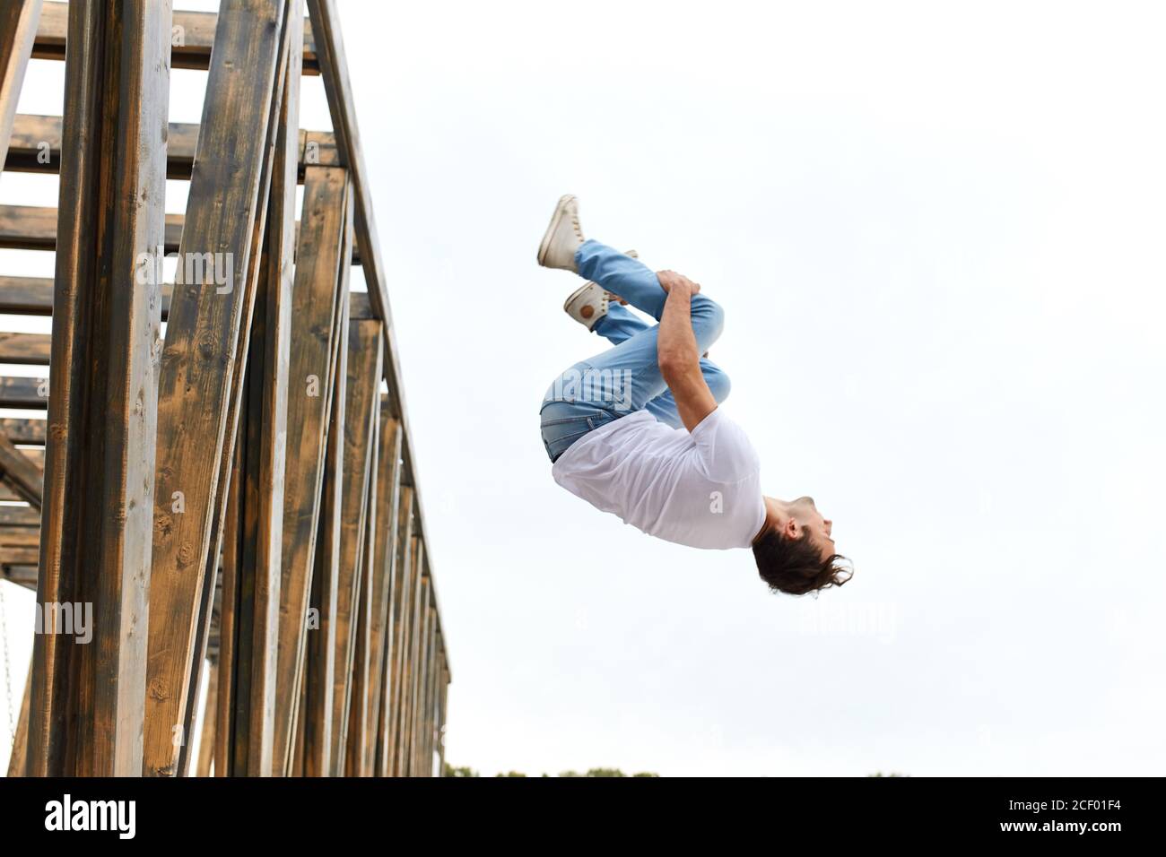 Sporty brave man performing risky stunt while jumping high in the air ...