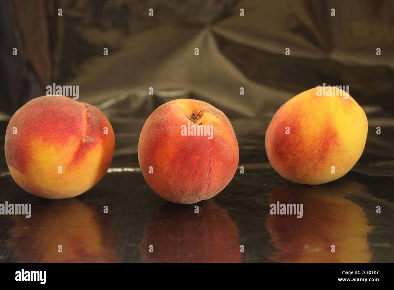 Three peaches on a black background Stock Photo - Alamy