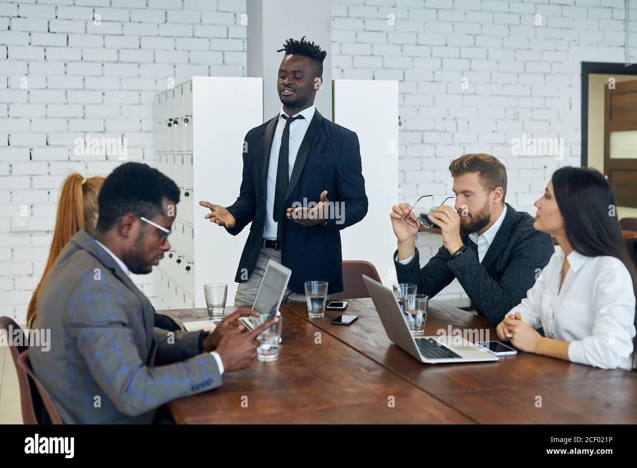 Personable black employee explains to foreign colleagues new client ...