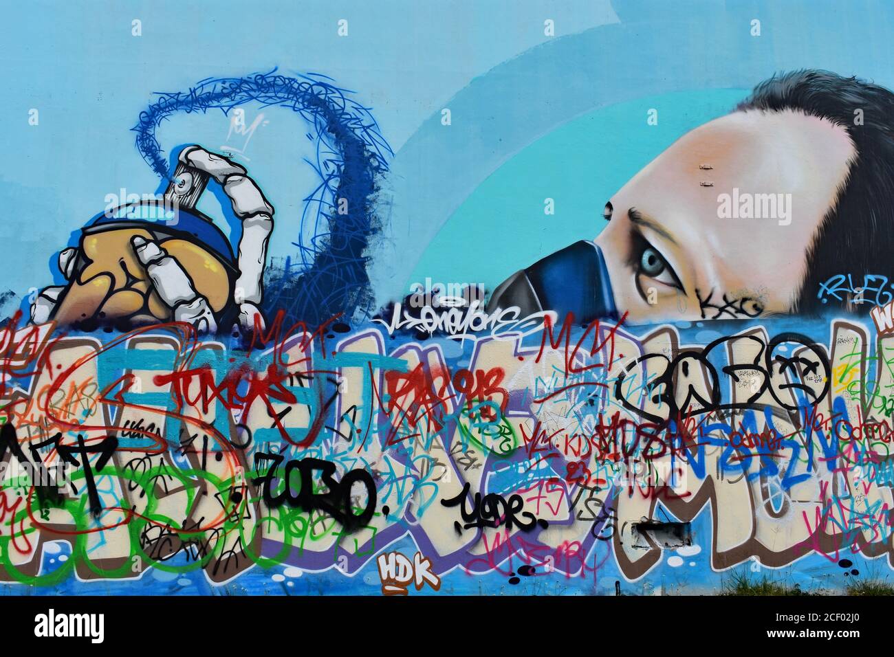 Graffiti shows a small portion of a mans head, wearing an facemask and ...