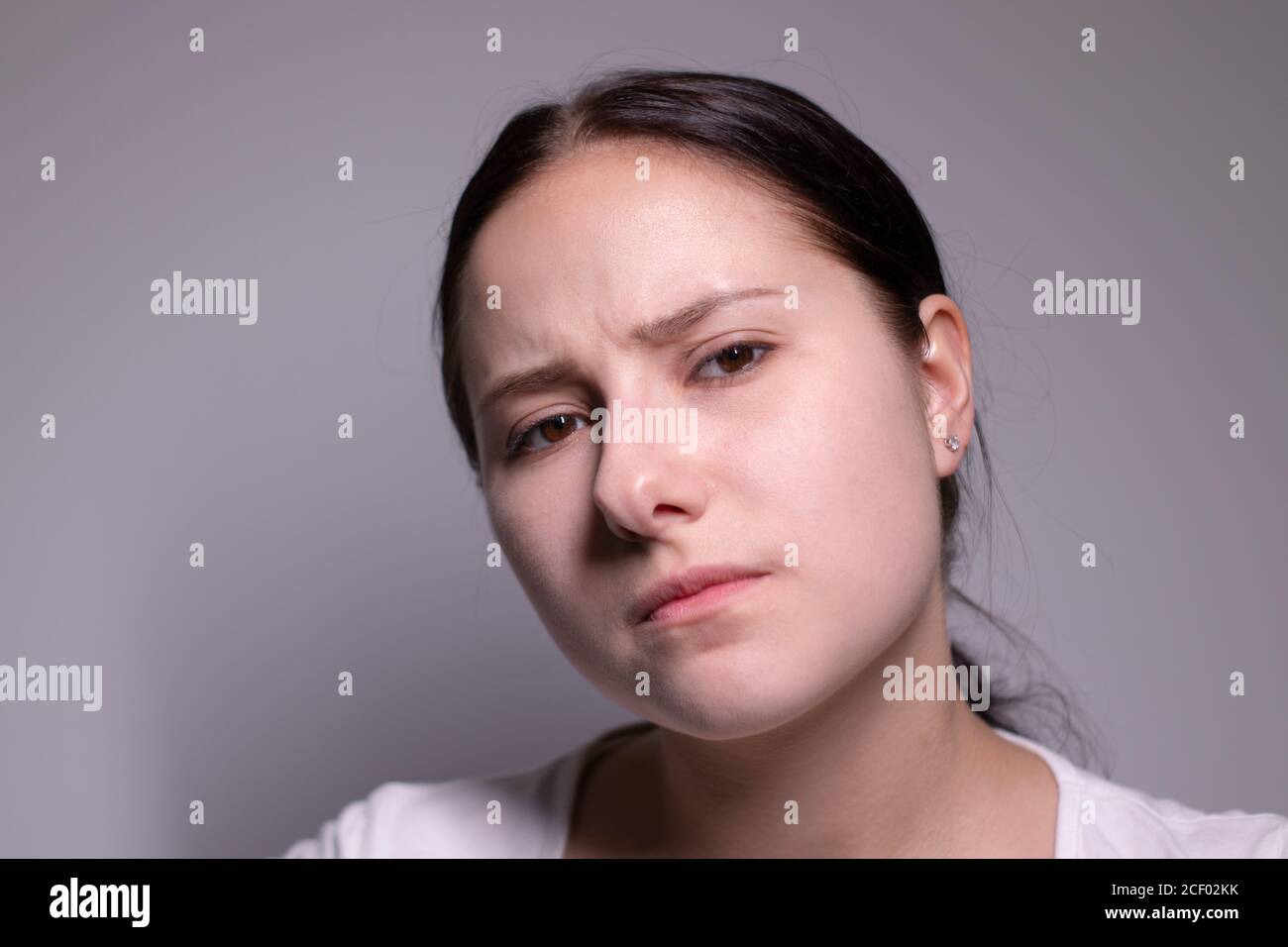 portrait of sad and depressed young woman. on gray background. nervous ...