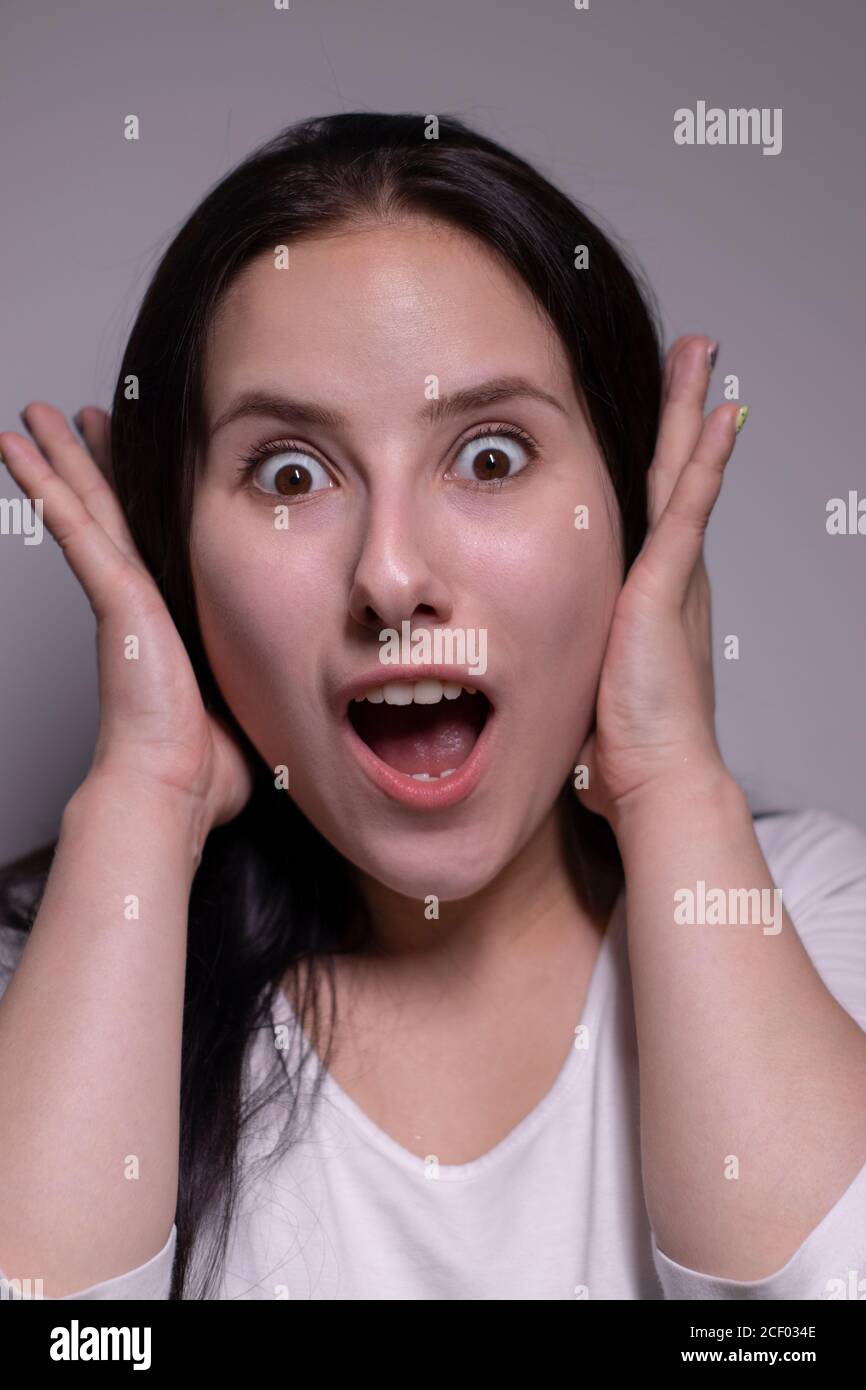 surprised brunette, isolated on gray background. happy girl actress ...