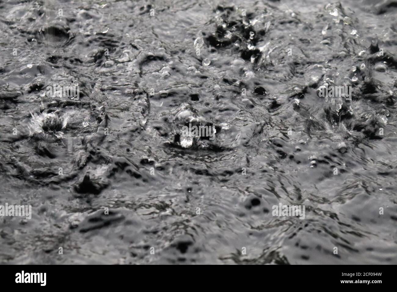 Rain drops in a puddle Stock Photo - Alamy