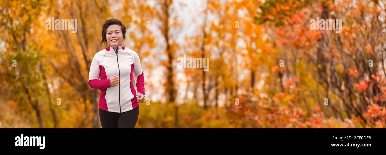Autumn running middle age woman jogging banner Stock Photo - Alamy