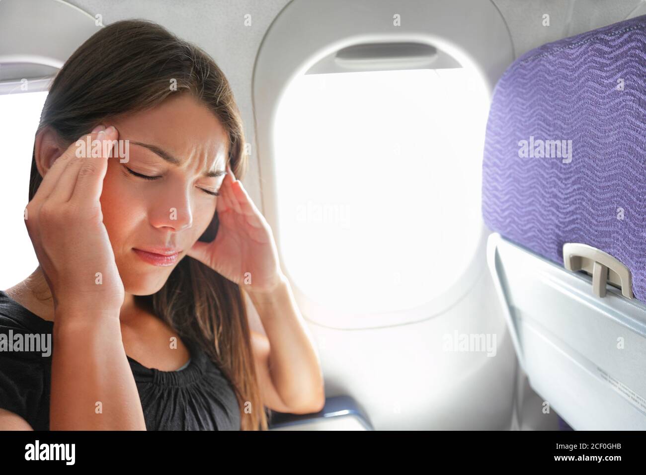 Travel plane sick woman fear of flying headache Stock Photo - Alamy