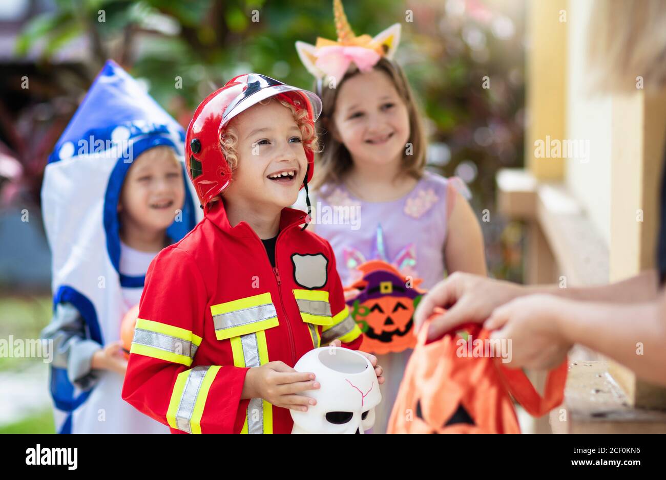 Kids trick or treat in Halloween costume. Children in colorful dress up ...