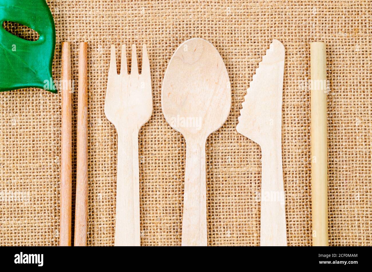Set of the wooden kitchen utensils with green leaf on sack background ...