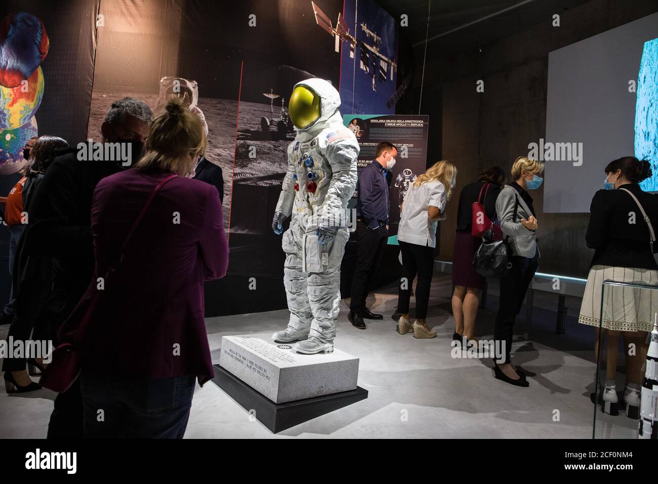 Visitors wearing facemasks explore the Moon rock exhibition and a ...