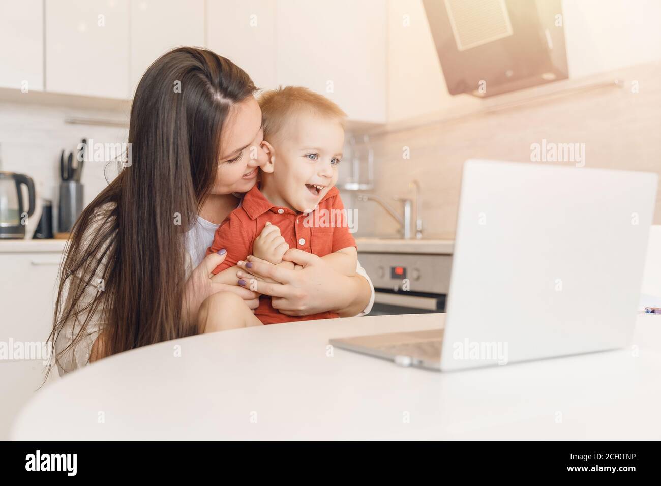 Woman and baby son having web video call with happy family on computer ...
