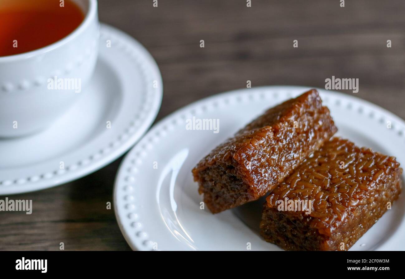 Wajik and a cup of tea on wood background. Wajik is traditional snack ...