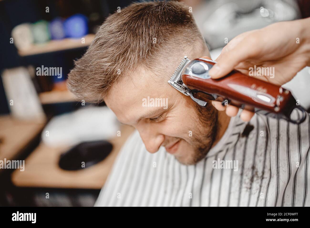 Barber in Barbershop shear hair electric to young guy for fashionable ...