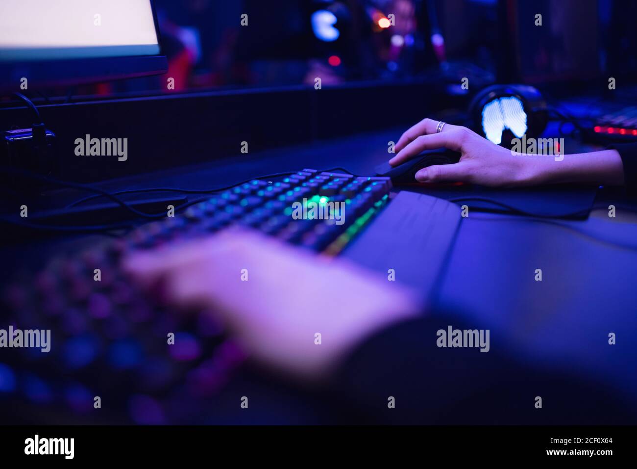 Professional online gamer hand fingers mechanical keyboard in neon ...