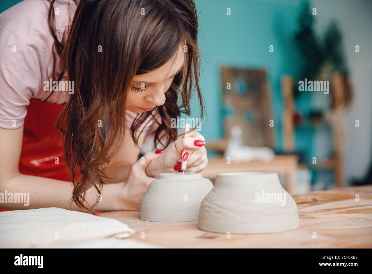 Beautiful potter girl makes pottery for roasting in oven. Concept ...