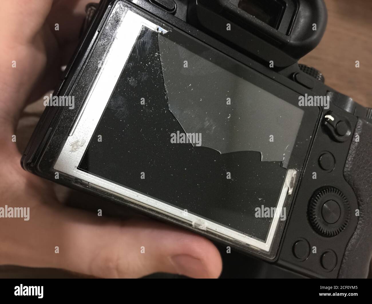 Camera with broken glass on the display in the hands of the repairer ...